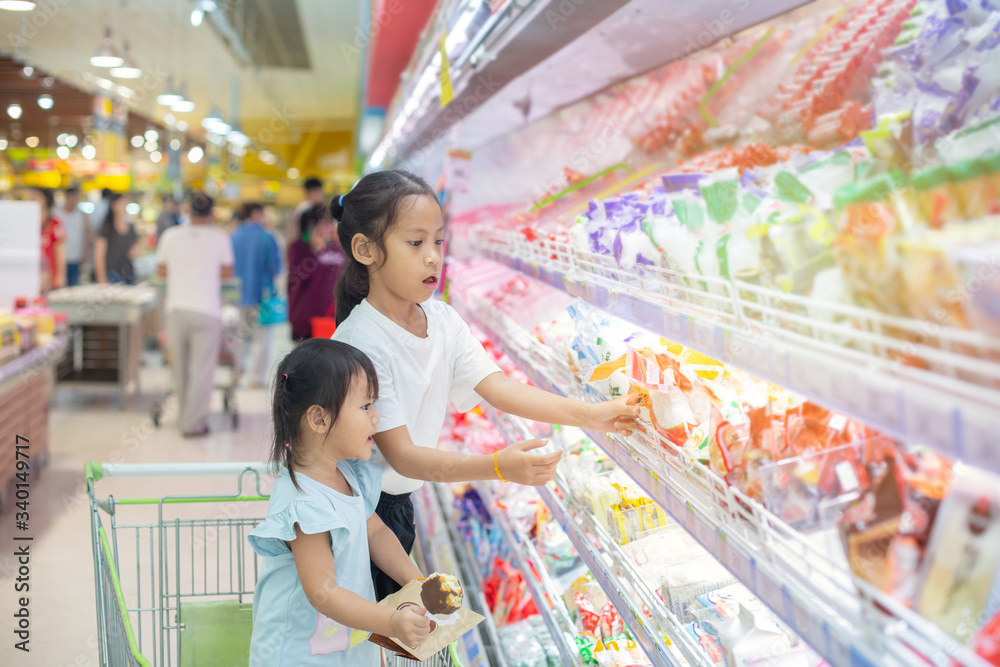 Asian children girl on the cart shopping choose to see fresh food in ...