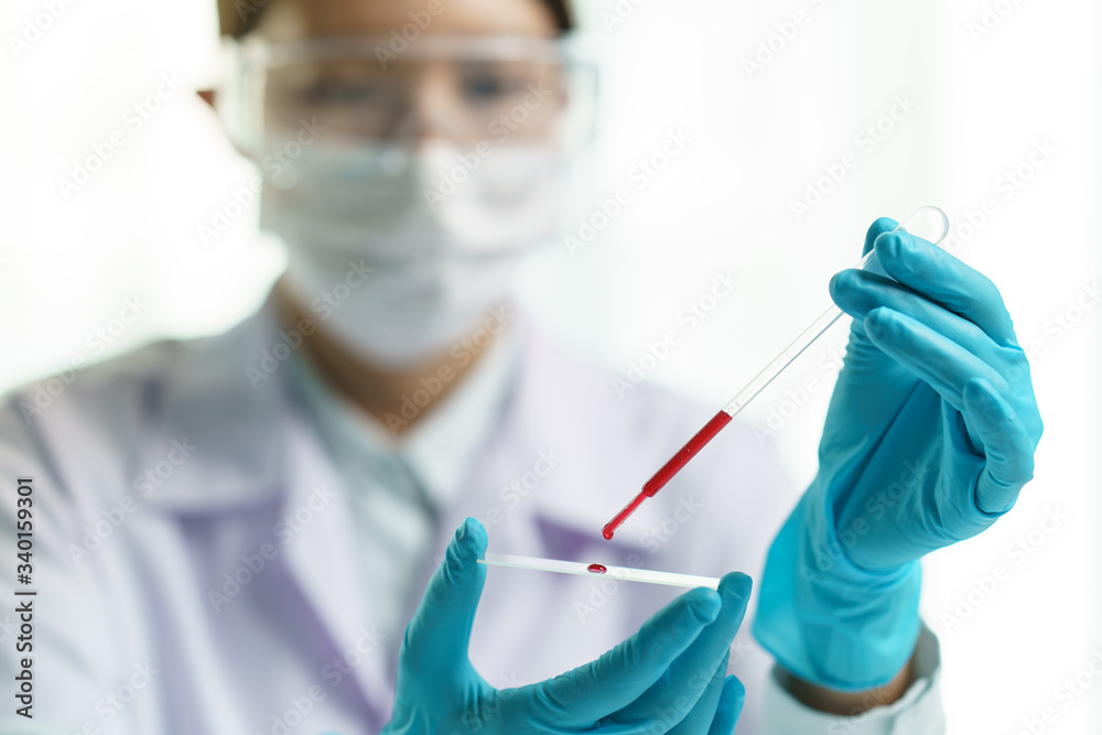 Lab technician dripping blood on slide glass for blood group test in ...
