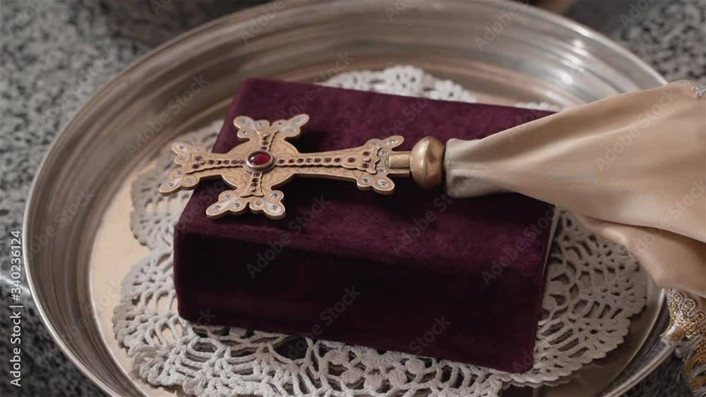 The Holy cross with red decorations lies on the Bible in the Church ...