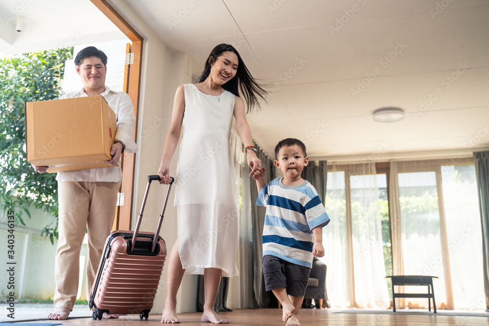 Asian family moving to new house, father holding big box standing near ...