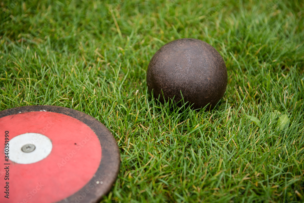 Shot put and discus on the grass, track and field equipment Stock Photo ...