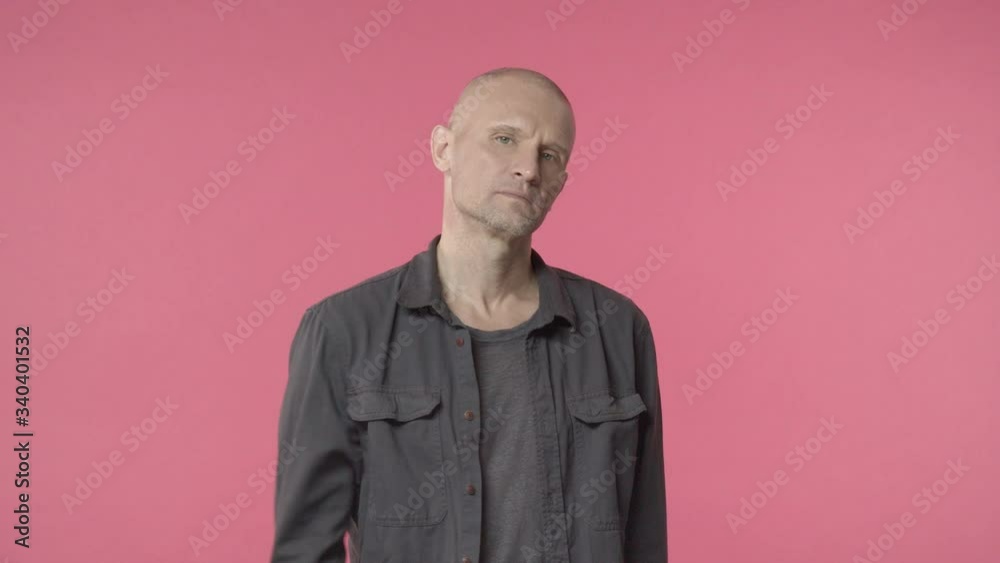 Middle-aged serious-looking bald man with grey bristle, look camera ...