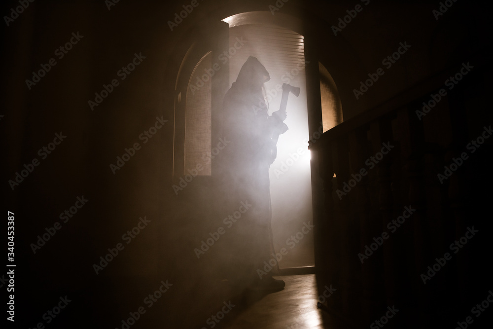 Silhouette of an unknown shadow figure on a door through a closed glass ...