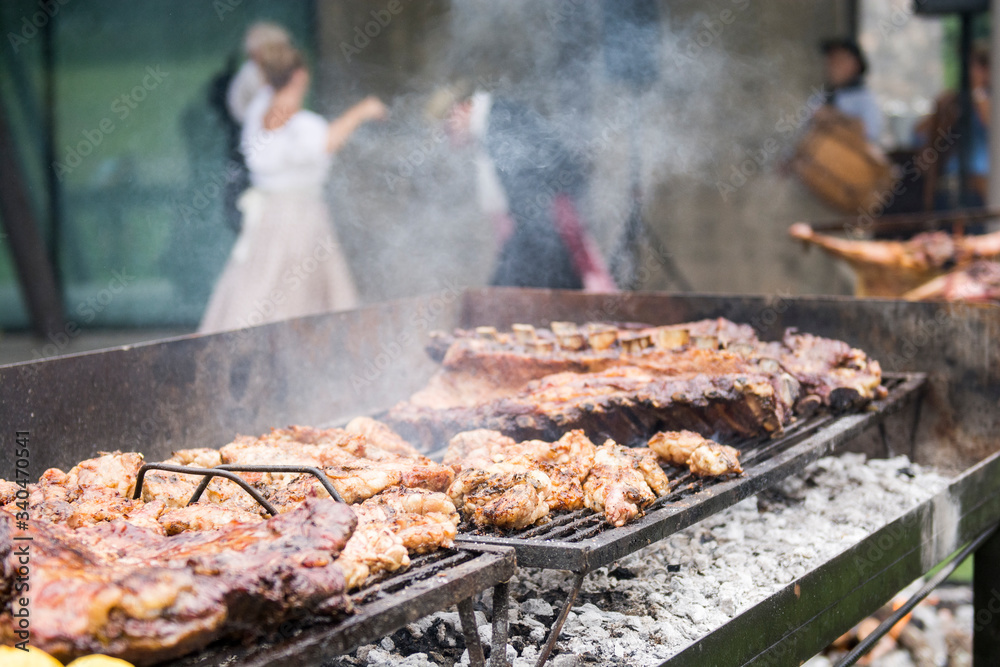 Asado Argentino a la parrilla con gauchos bailando en el fondo. Stock ...