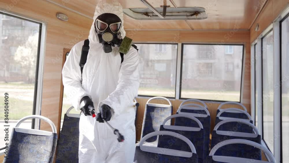 Hazmat team worker disinfects bus seats with antibacterial sanitizer ...