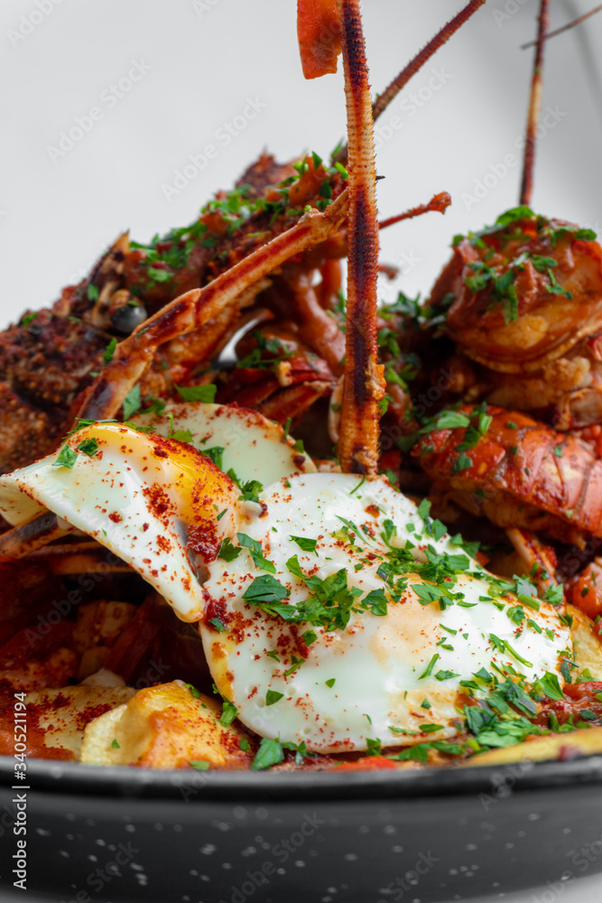 Formentera Lobster with fried potatoes, eggs and parsley in a ...