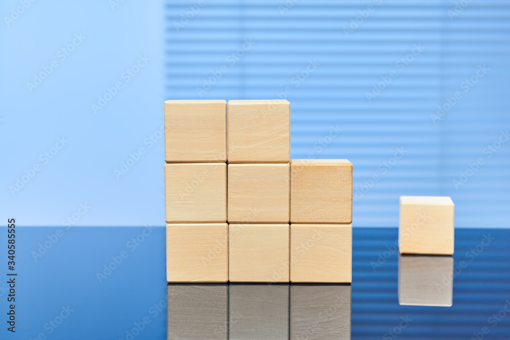 Nine wooden cubes on a blue background standing on top of each other in ...
