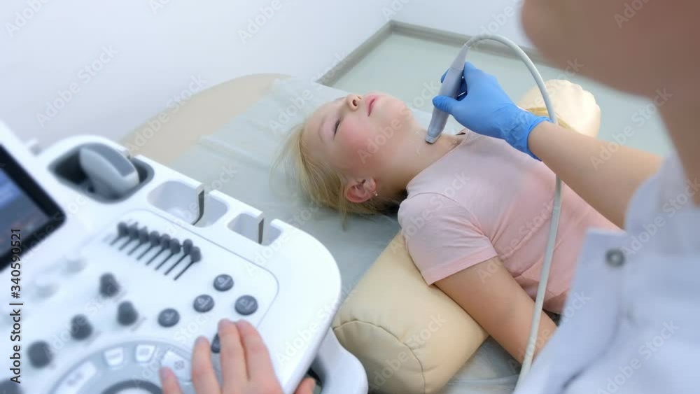 Doctor diagnostic examining patient child girl thyroid gland using ...