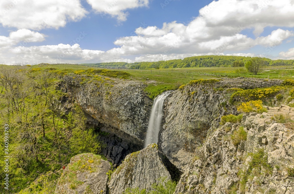 Waterfall between stone wall and blue sky, cascade entre des roches ...