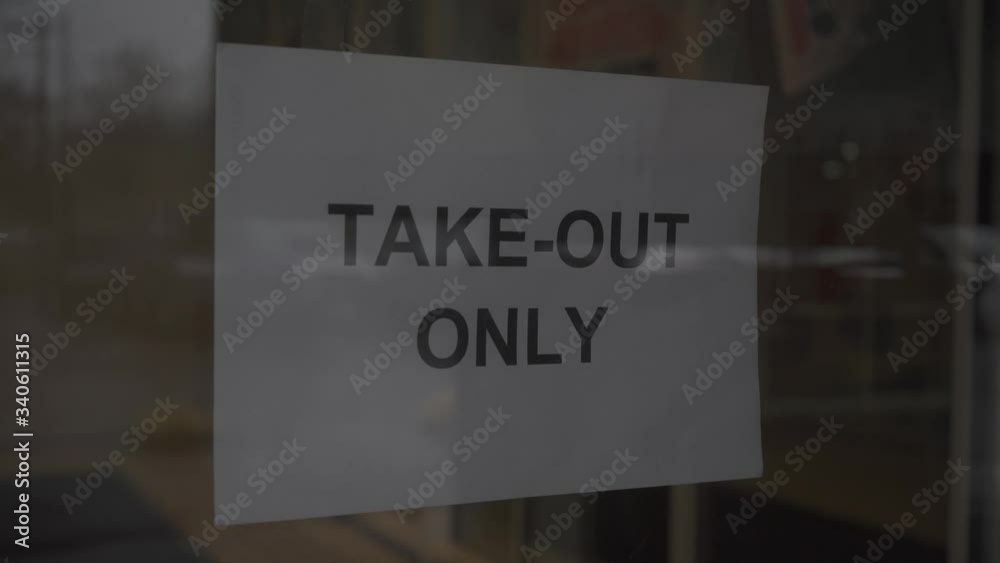 A cafe owner puts a TAKE OUT ONLY sign on the front door. Take out or ...