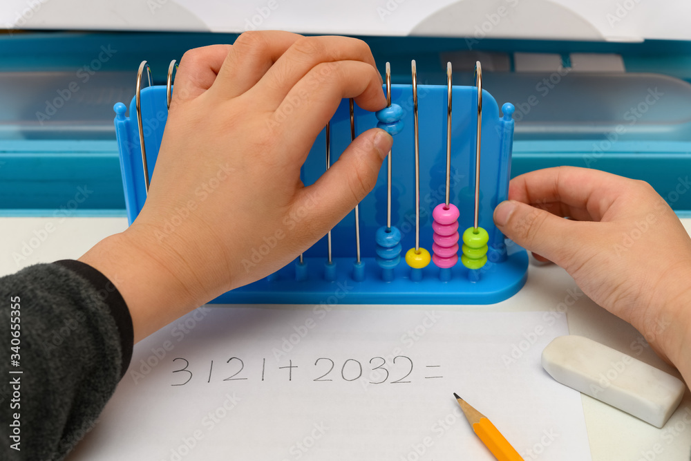 kid using abacus to calculate addition equation Stock Photo | Adobe Stock