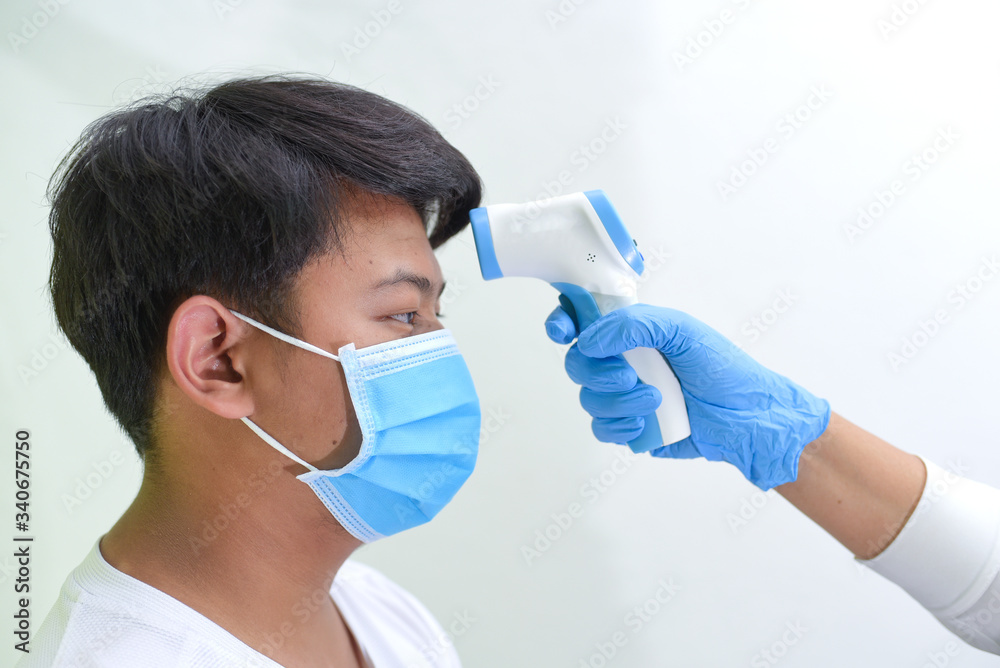 Hand holding infrared thermometer to measuring temperature on blurred ...