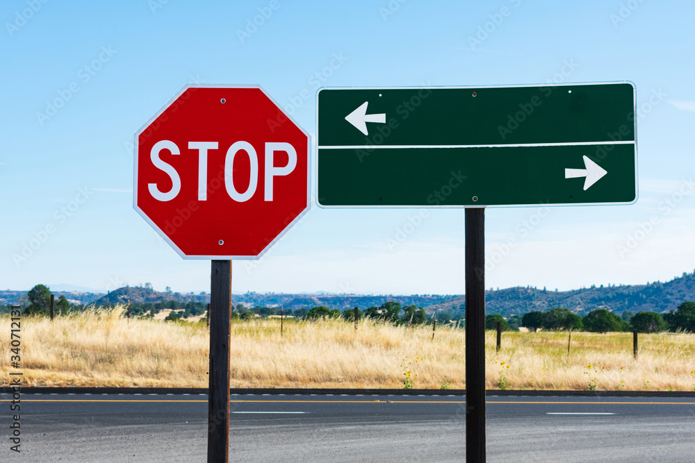 An 8-sided red STOP sign and rectangular shaped green guide road sign ...