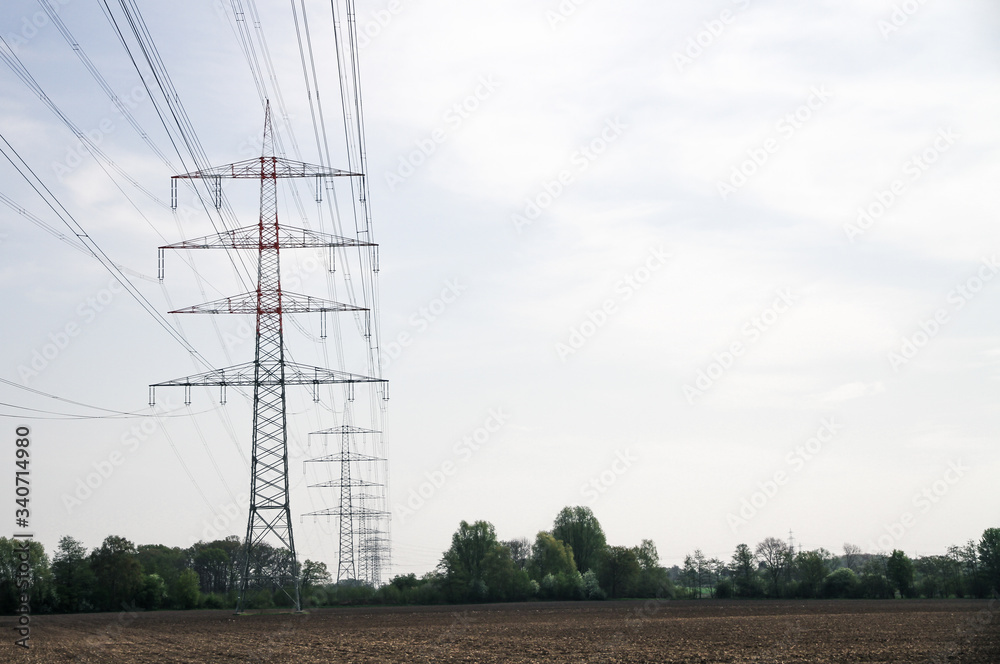 high voltage power lines, red and white electricity pylon with blue sky ...