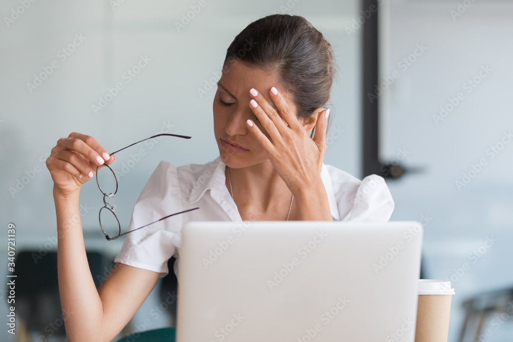 Woman taking off glasses touch forehead tired of computer work sitting ...