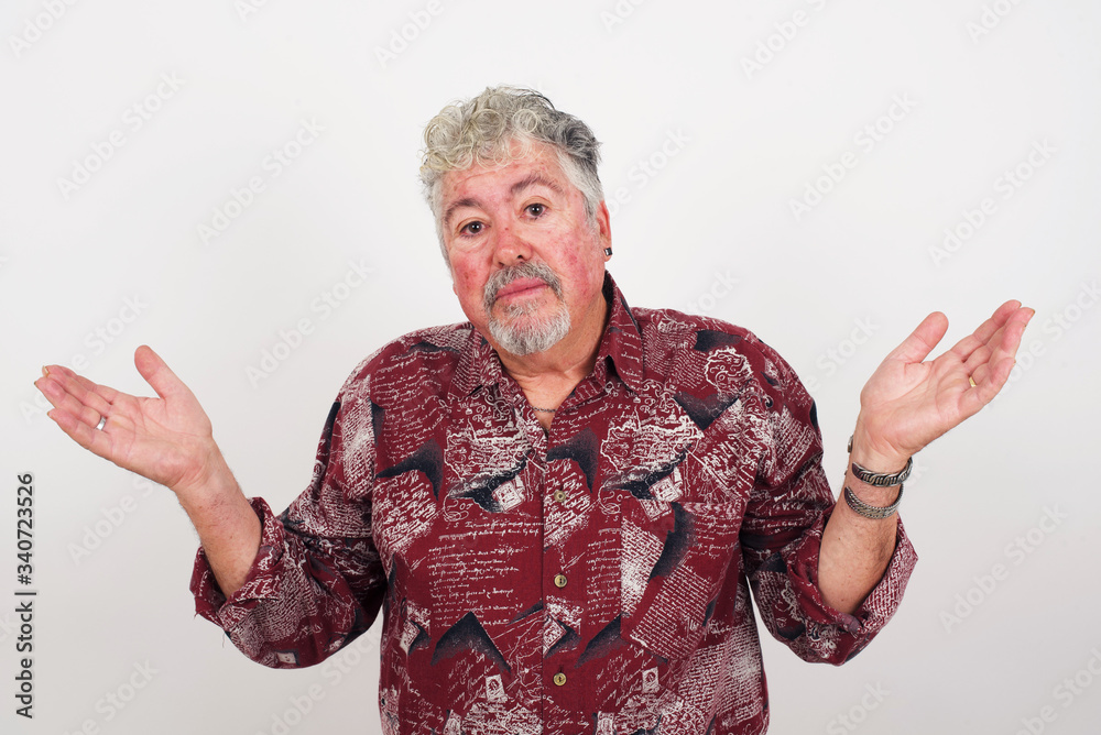 Puzzled and clueless young man with arms out, shrugging his shoulders ...