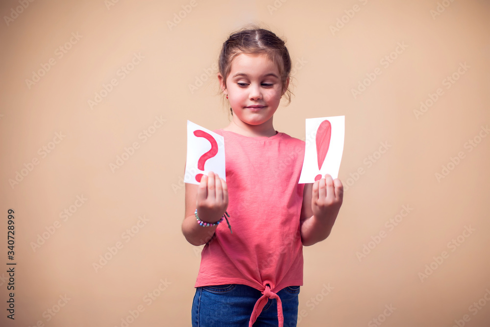 A portrain of kid girl holding cards with question mark and exclamation ...