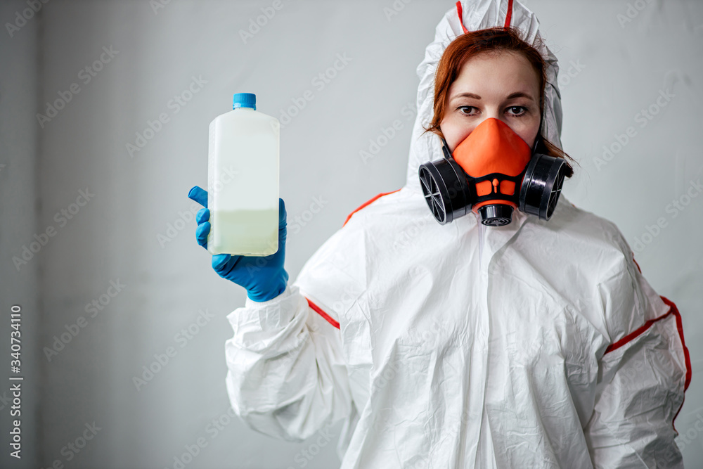 professional female disinfector holding disinfectant fluid in hands. people fight with ...