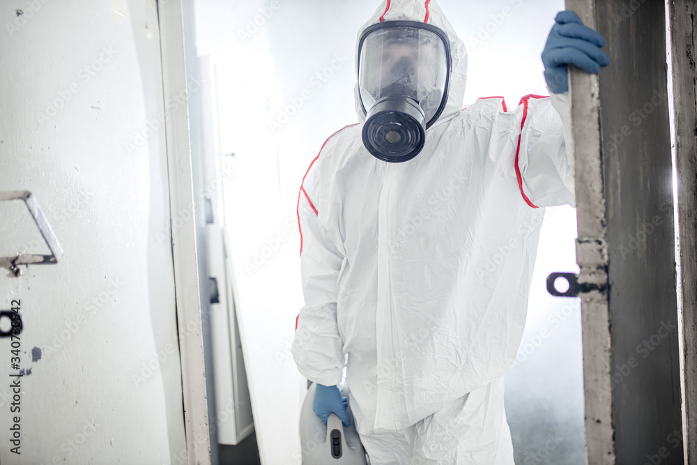 professional disinfector in an NBC personal protective equipment ppe ...