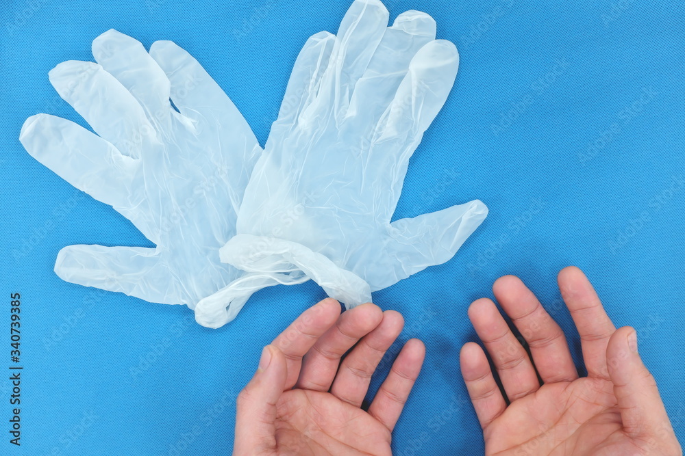 Bare hands and used gloves on table. Top view, flat lay in blue ...