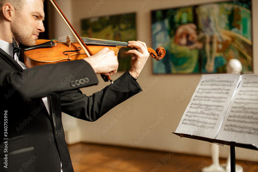young caucasian talented violinist play violin, handsome guy in formal ...