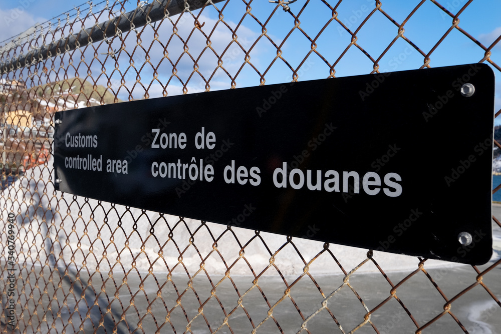 A black and white sign in English and French which says customs ...