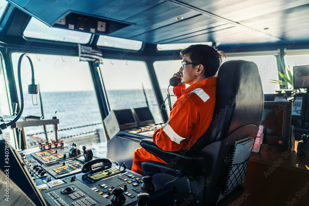 Filipino deck Officer on bridge of vessel or ship wearing coverall ...