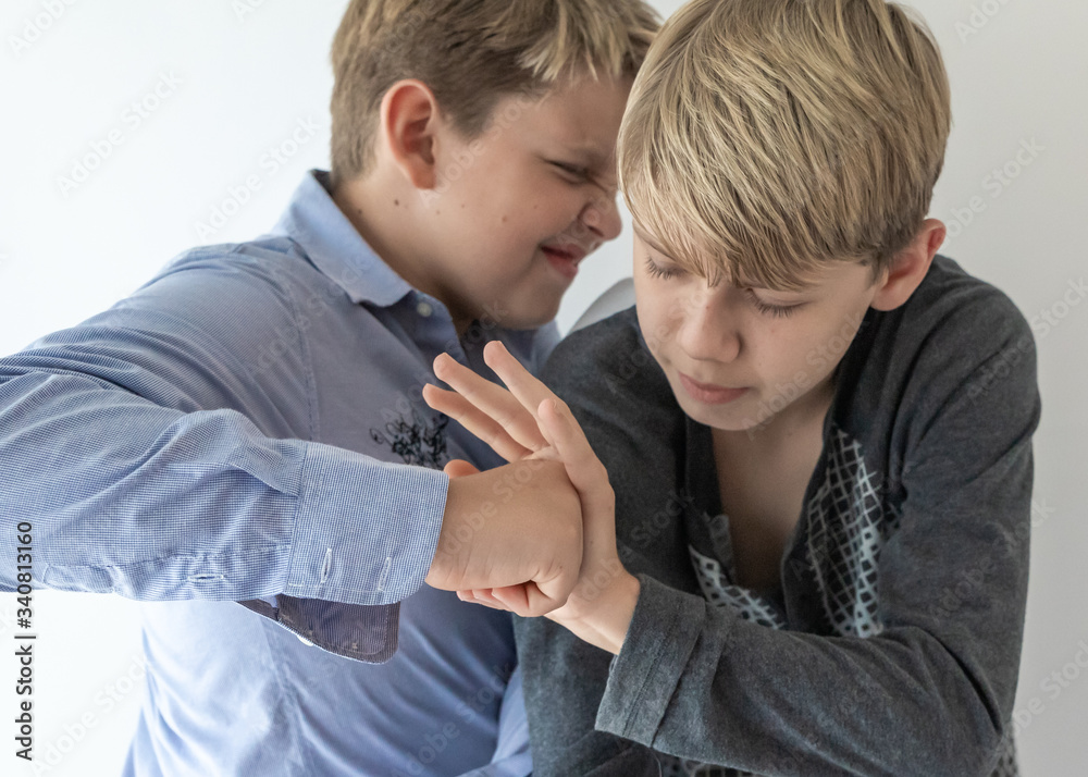 boys are fighting. bullying at school. the boy is attacking week boy. boy hitting face with a ...