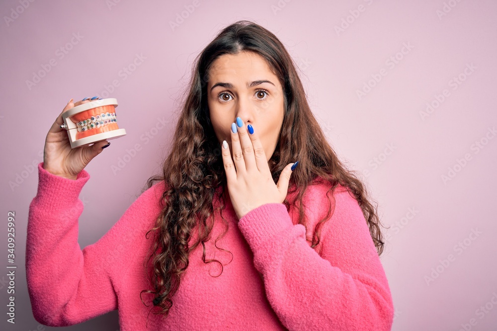 Beautiful woman with curly hair holding plastic teeth with dental ...