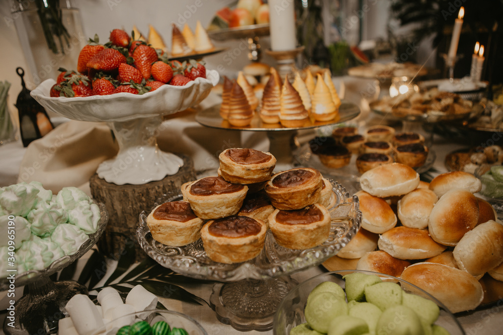 Plates with various pastry and strawberries placed on banquet table ...