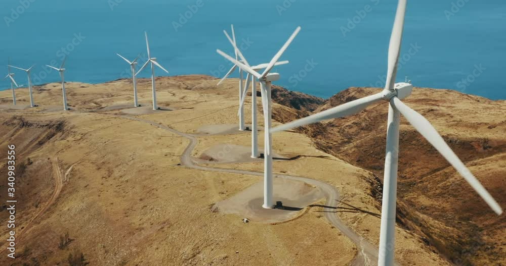 Cinematic aerial view of large wind turbines producing clean ...