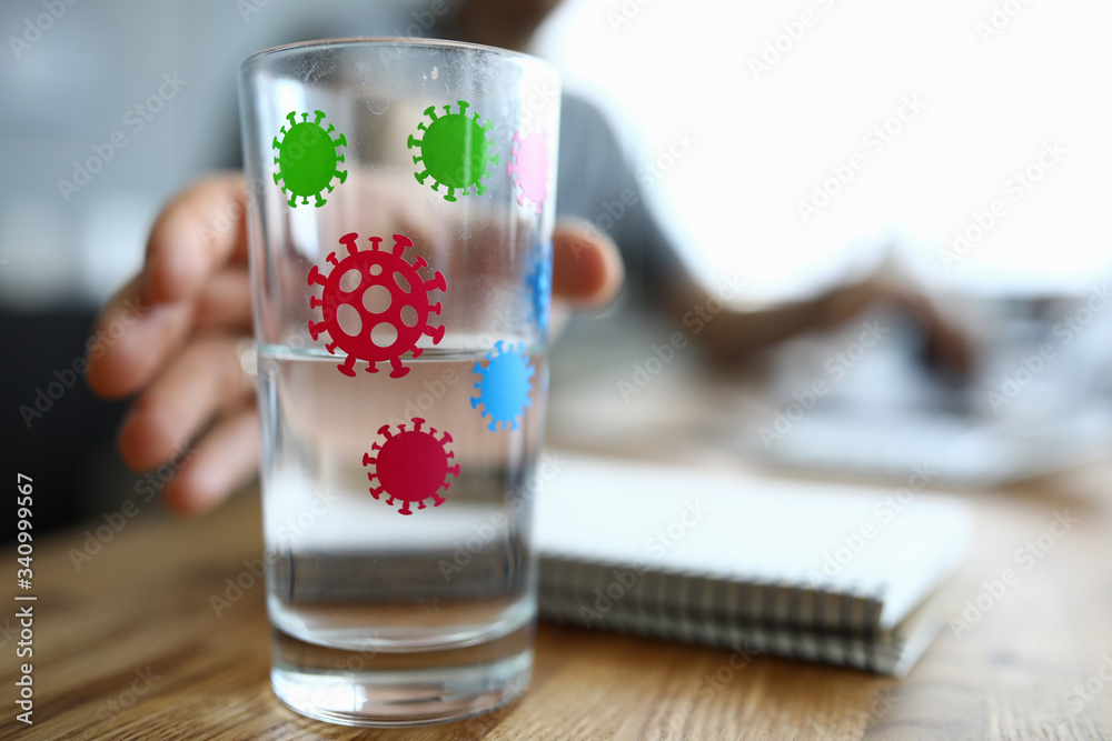 Hand reaches for glass infected with coronavirus. Acute respiratory ...