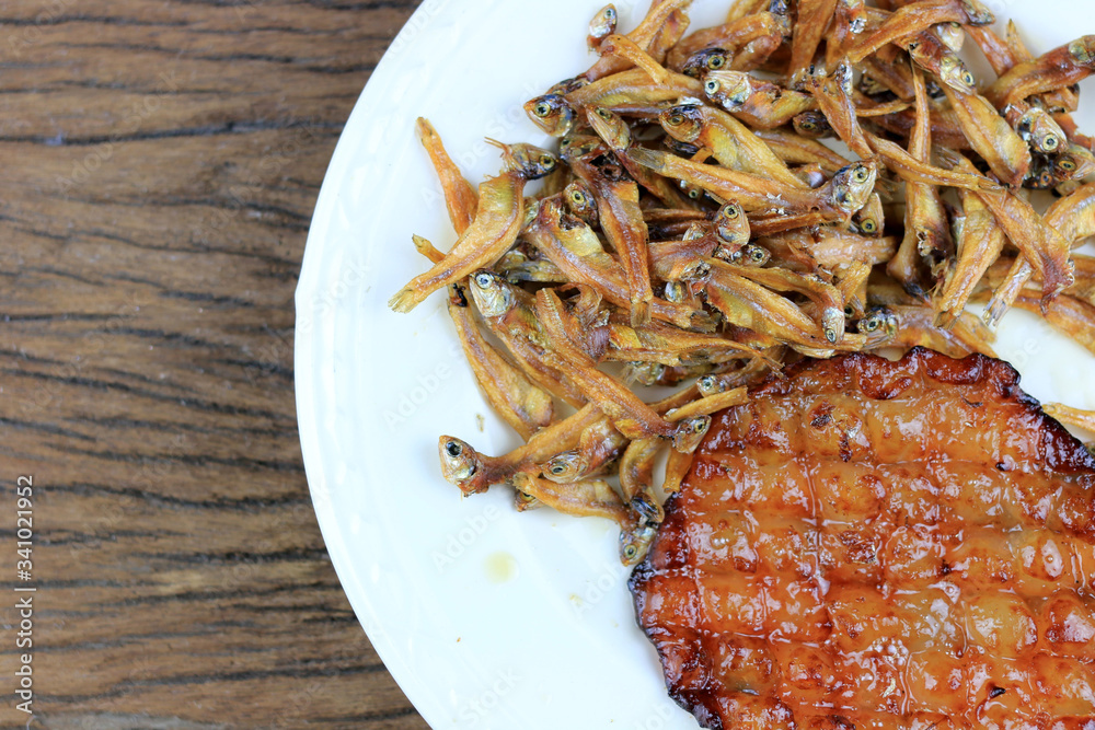 Fried giant catfish and pile of Deep fried small fishes (Minnow fish ...