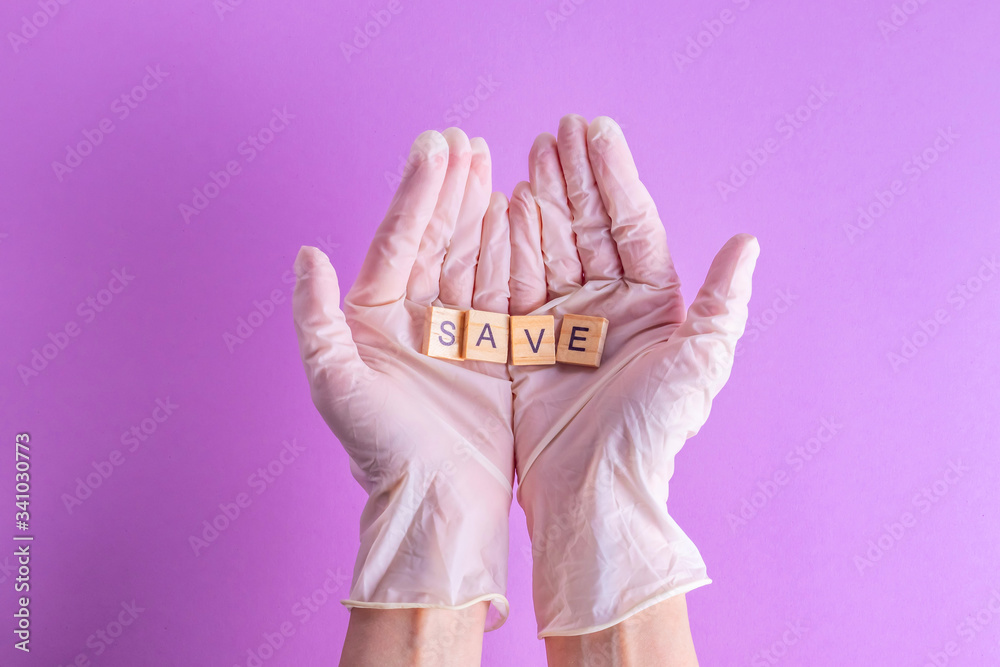 Save sign in palms with rubber gloves on a purple background Stock ...