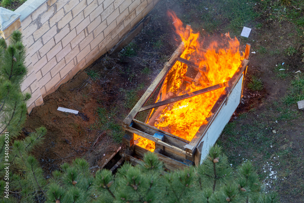 Fire coils over a burnt building. A pile of coals at the site of a ...