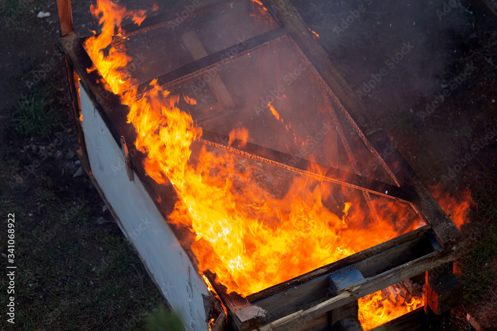 Fire coils over a burnt building. A pile of coals at the site of a ...
