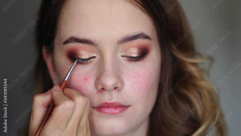 Makeup artist paints eyelids on a model girl. Stock Video | Adobe Stock