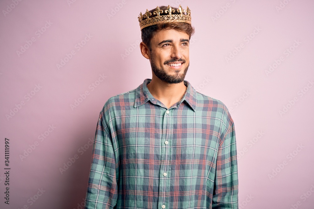 Young man with beard wearing golden crown of king standing over ...