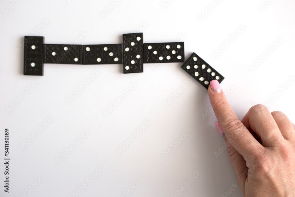Female hand puts domino bone in a line, top view. Play dominoes. Board ...