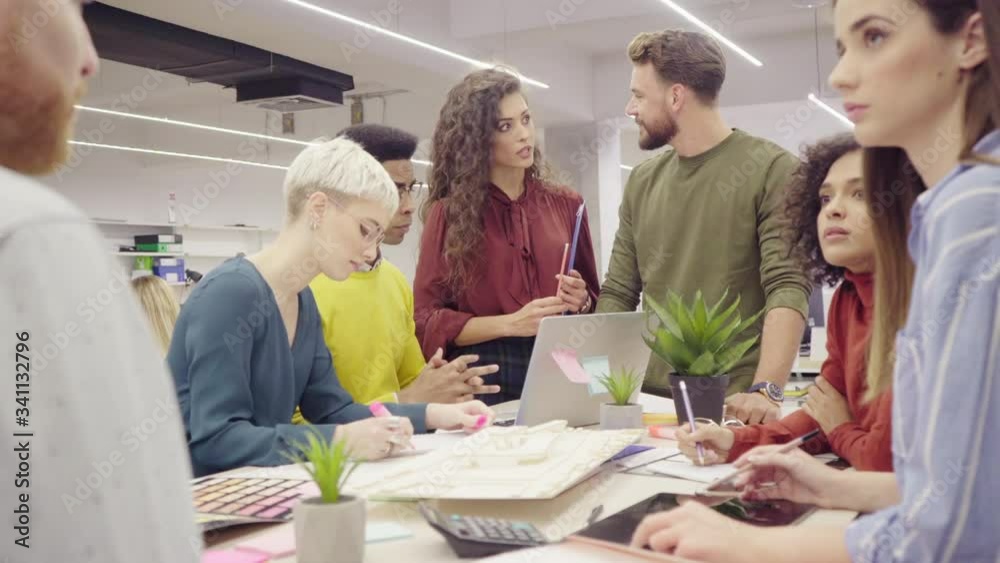 Smiling business team working on construction plan and laptop. Happy ...