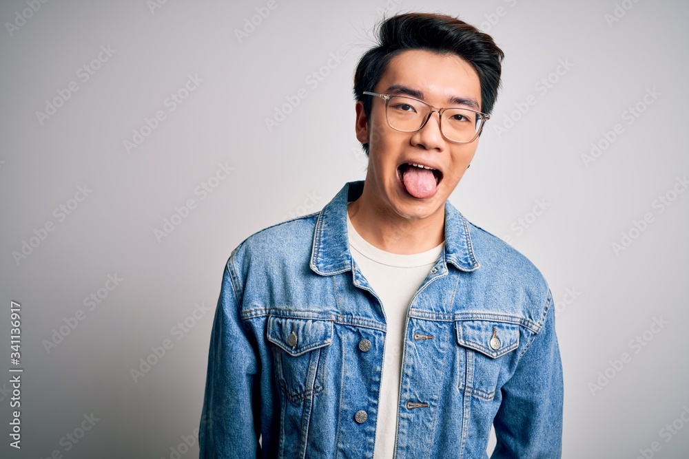 Young handsome chinese man wearing denim jacket and glasses over white ...