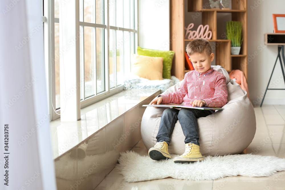 Cute little boy reading book at home Stock Photo | Adobe Stock