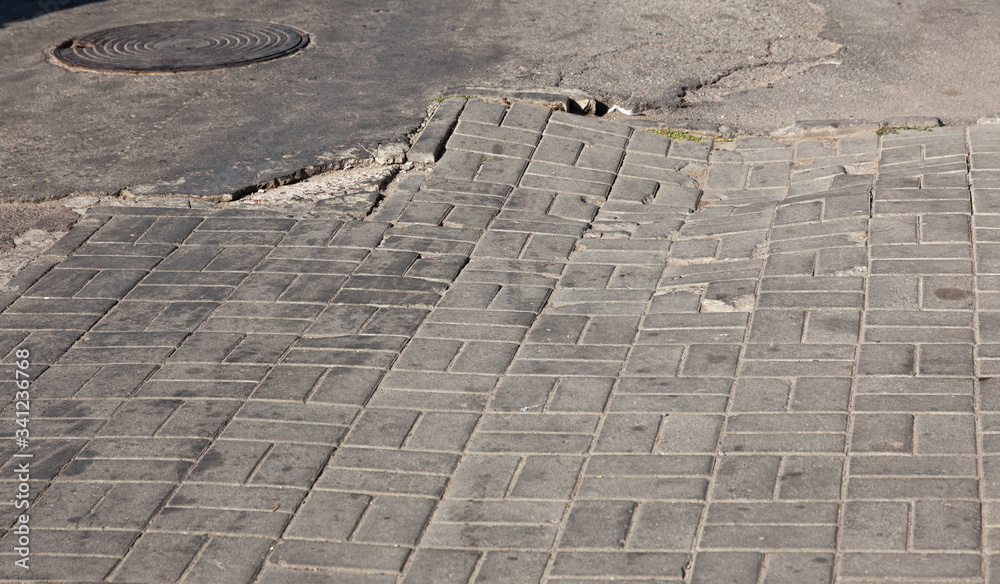 Damaged road with potholes, caused by freeze-thaw cycles in winter. Bad ...