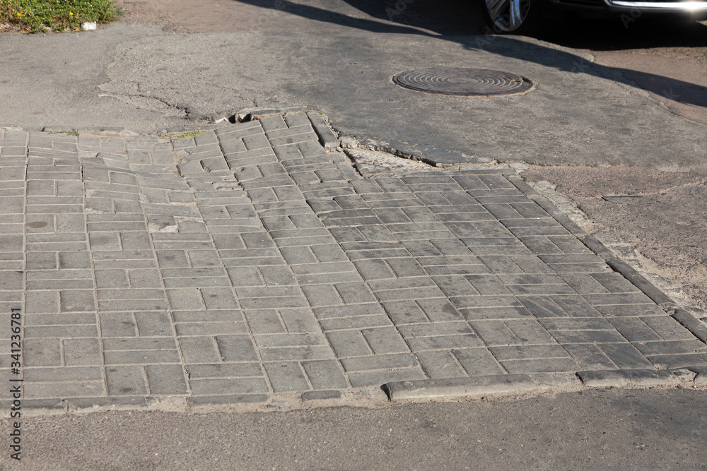 Damaged road with potholes, caused by freeze-thaw cycles in winter. Bad ...
