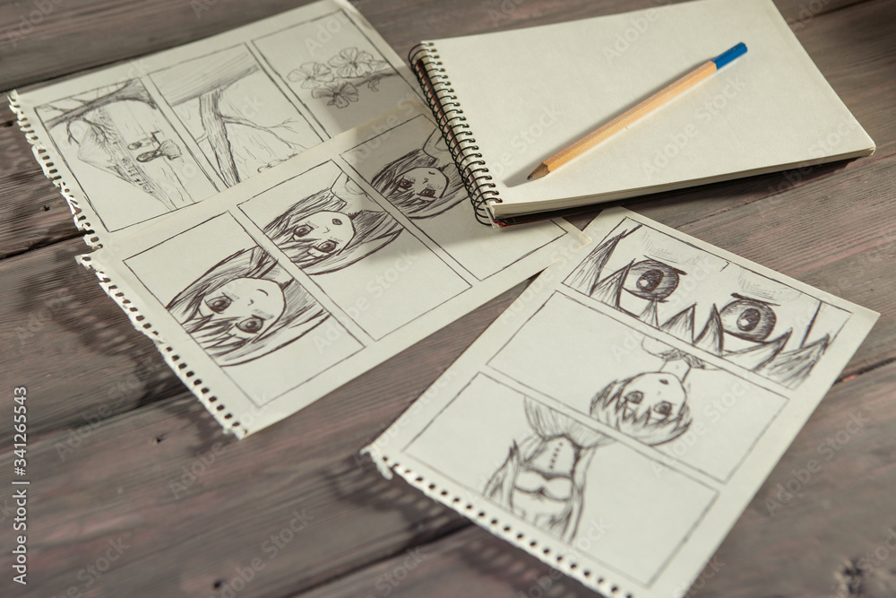 Artist drawing an anime comic book in a studio. Wooden desk, natural ...