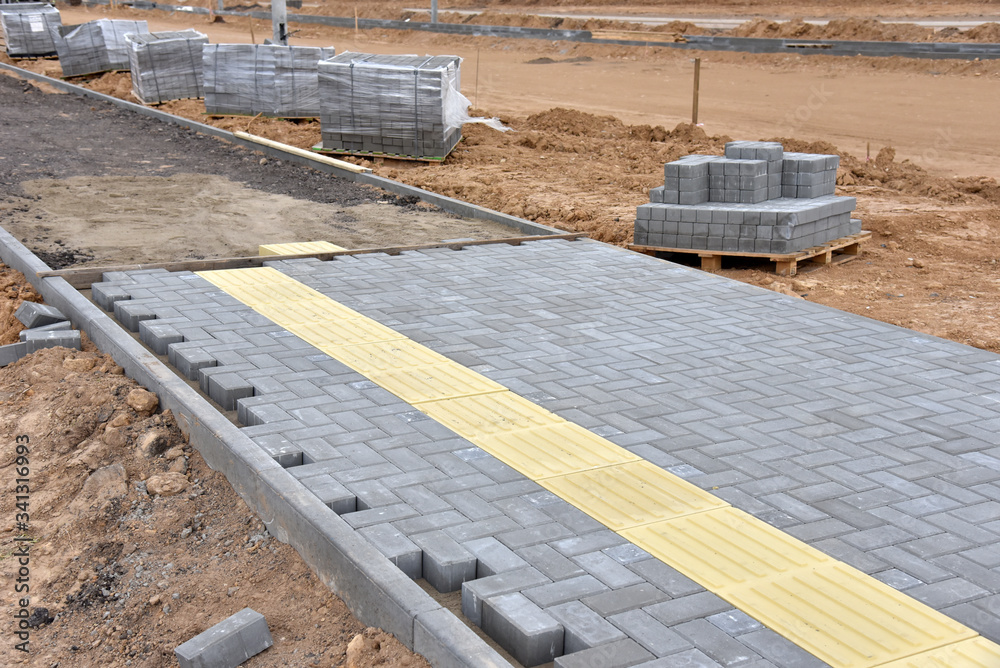 Laying paving slabs at construction site. Process of installing paving ...