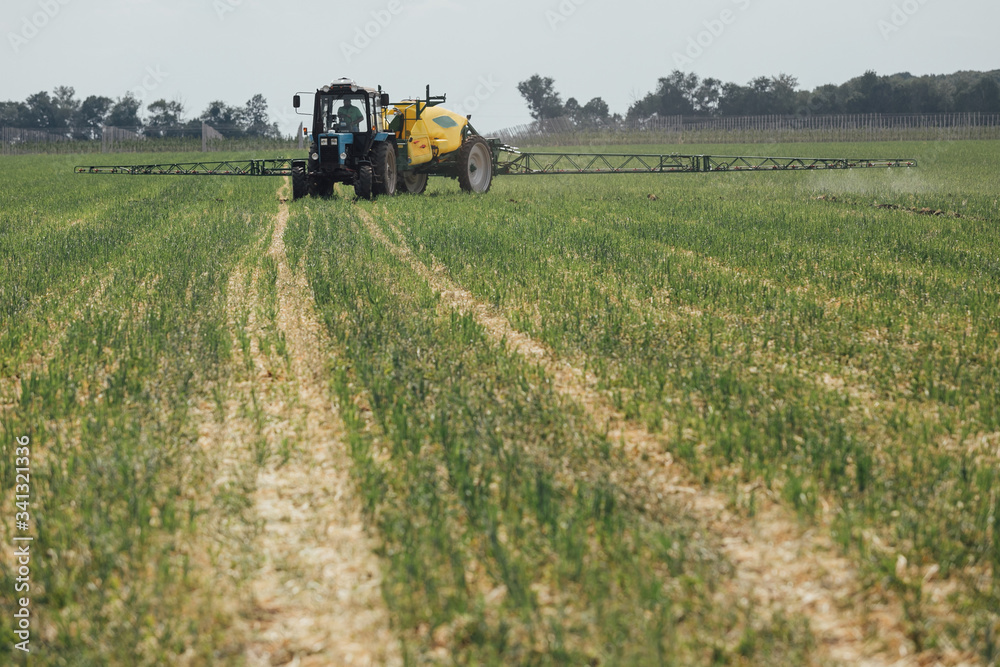 chemical treatment of plants to protect against pests using a tractor ...