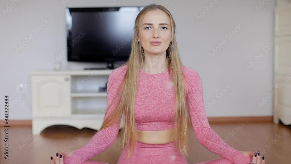 Vidéo Stock Pretty and happy woman siting on fitness mat in butterfly ...