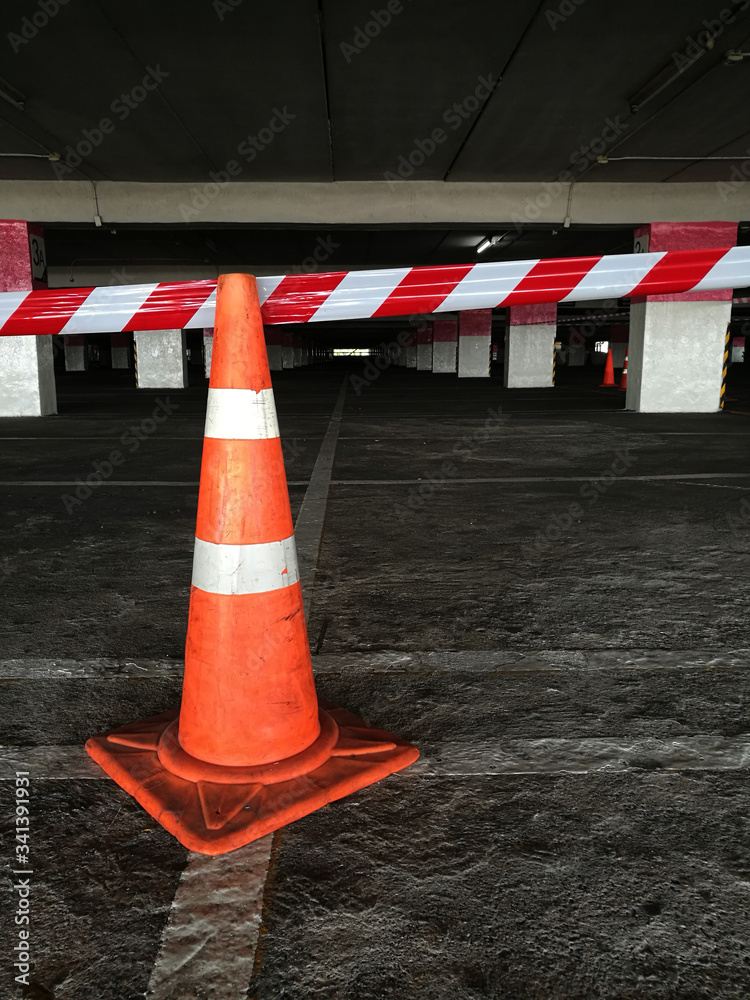 An orange traffic cone and red and white tape. It's "no entry" sign put ...