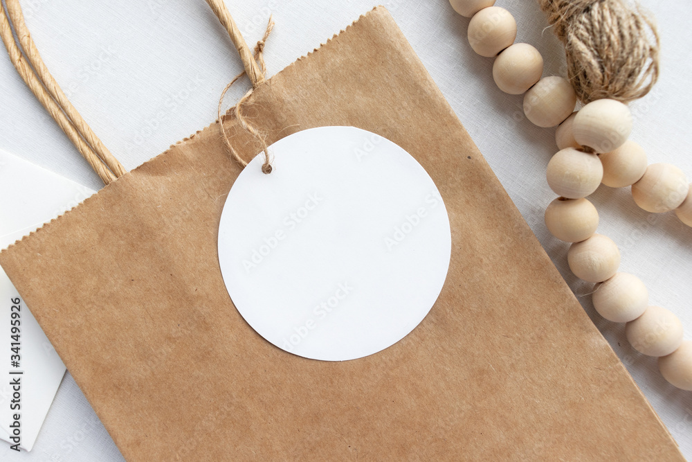Round gift tag label on a brown paper bag - flat lay gift tag mockup ...